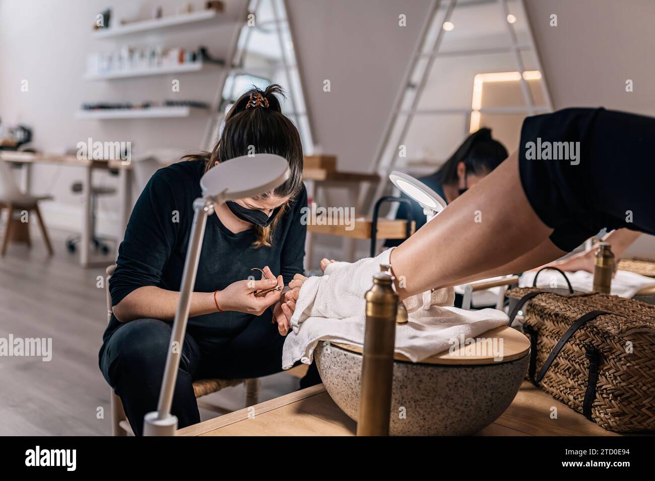Side view of crop anonymous female client getting pedicure treatment ...