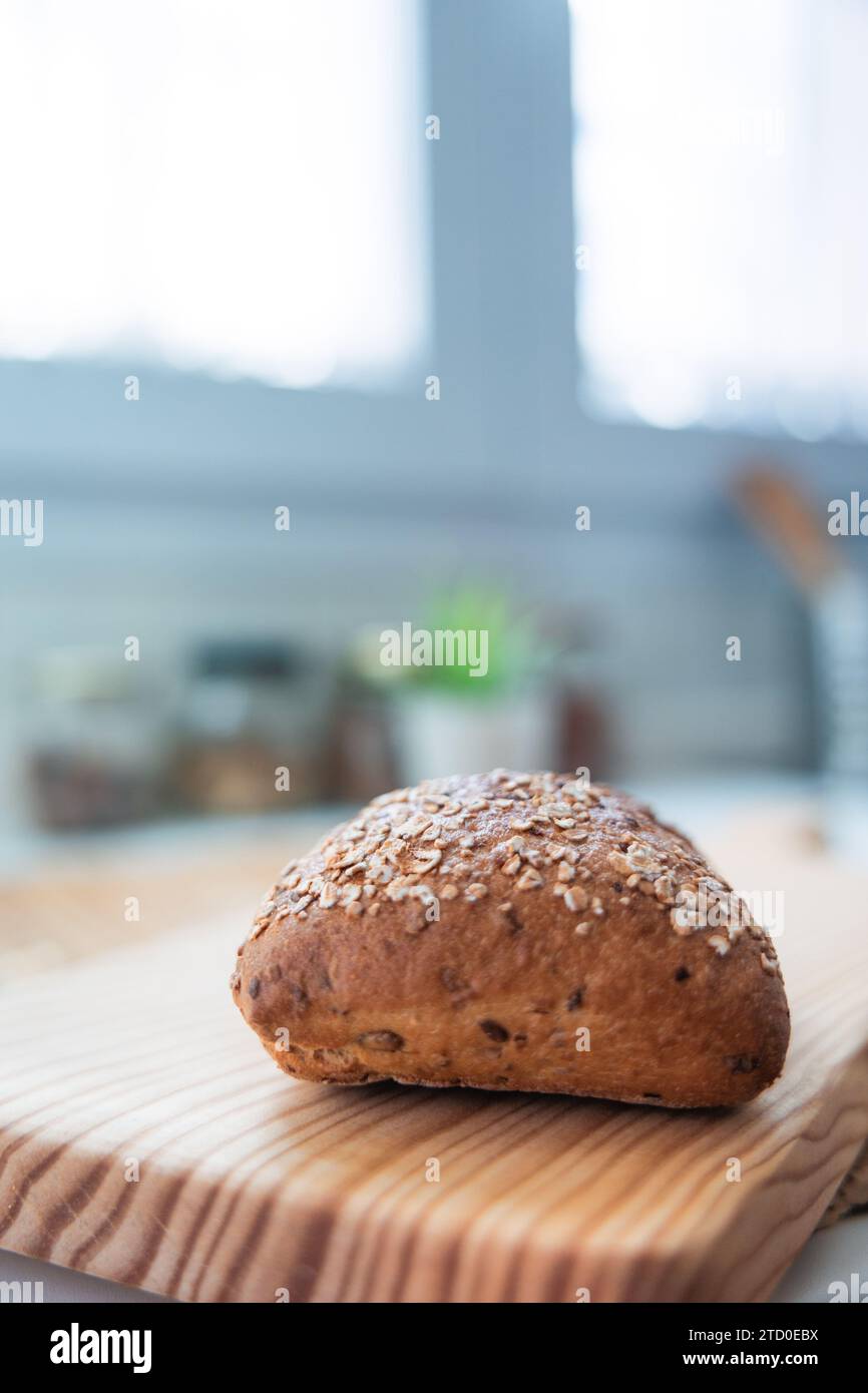 A seed-encrusted artisan bread loaf on a pine wood cutting board, with ...