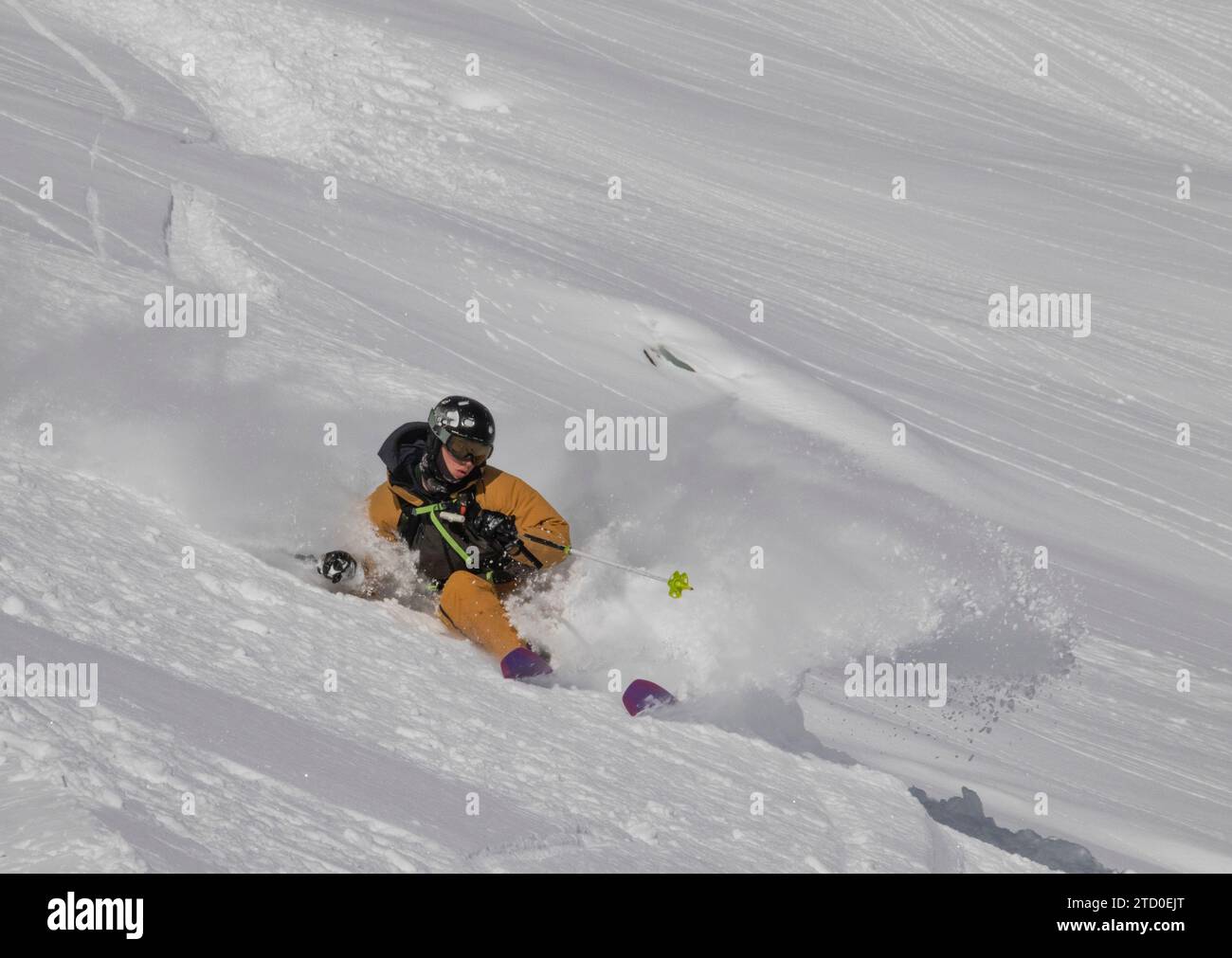 Full body of skier in warm suit skiing on snow covered mountain slope ...