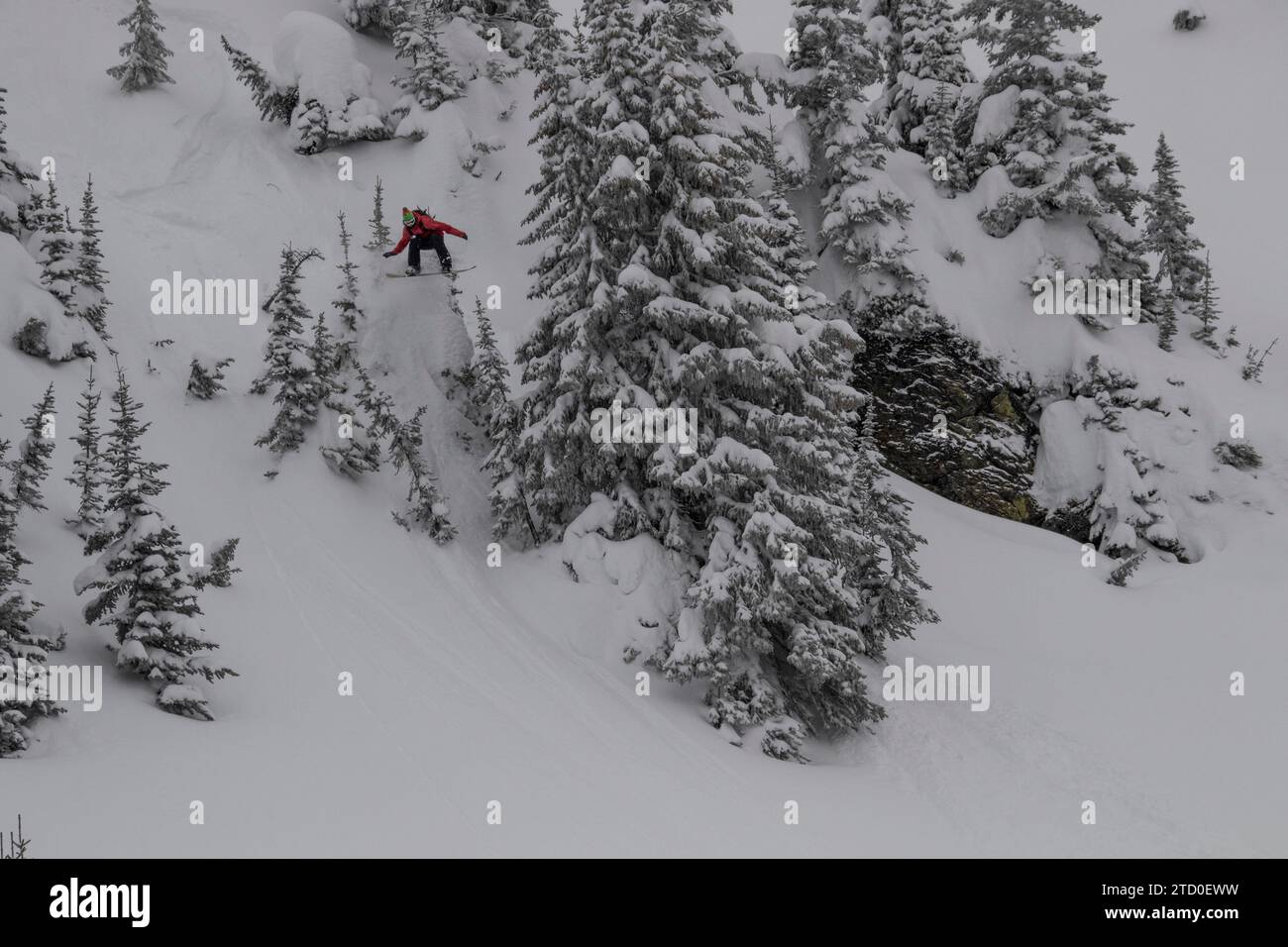 Adventures carefree person with snowboard jumping above snow covered ...