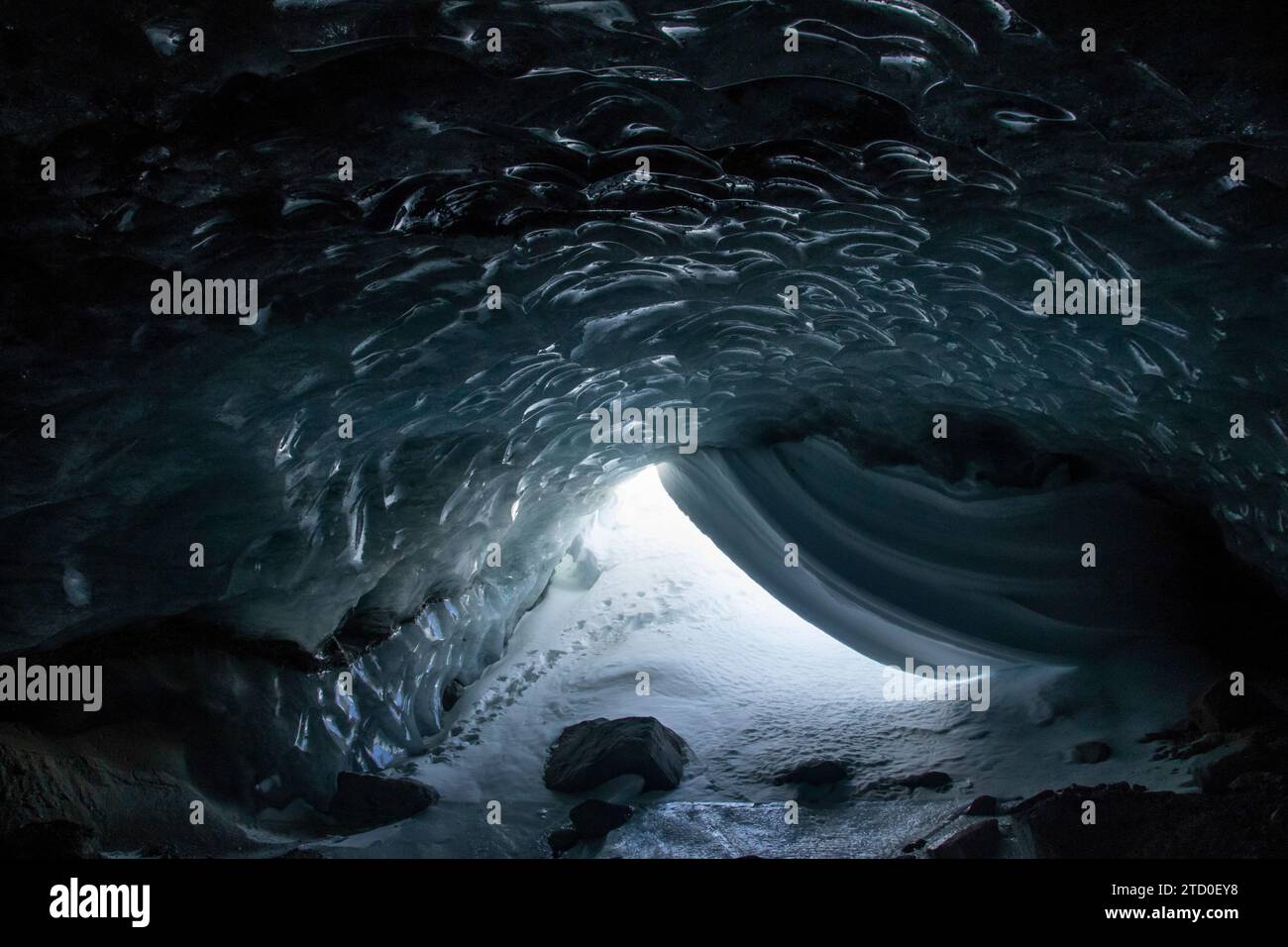 Interior of breathtaking frozen cave with snow covered rocky field and ...