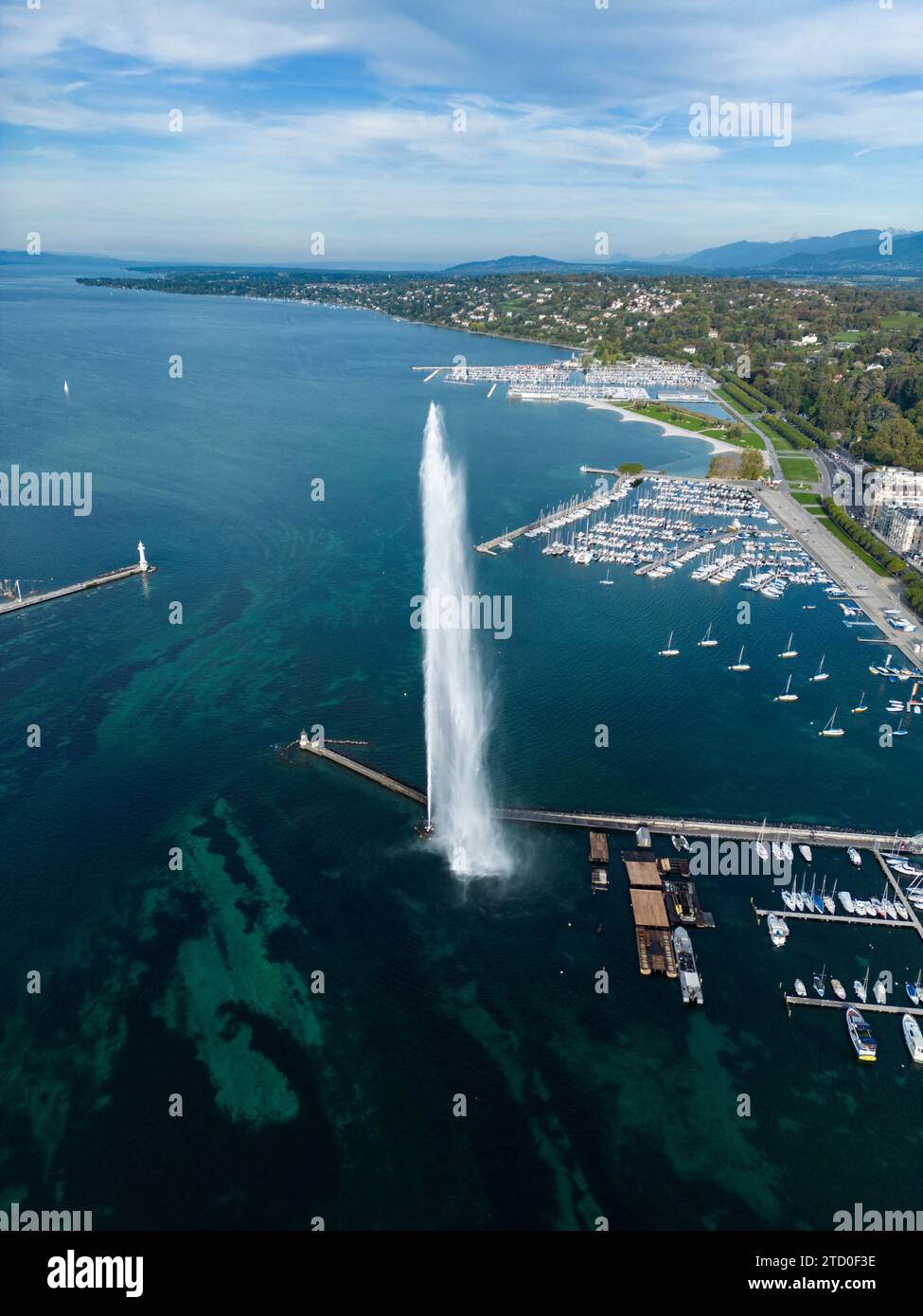 Aerial shot capturing a large water jet fountain in a bustling marina ...