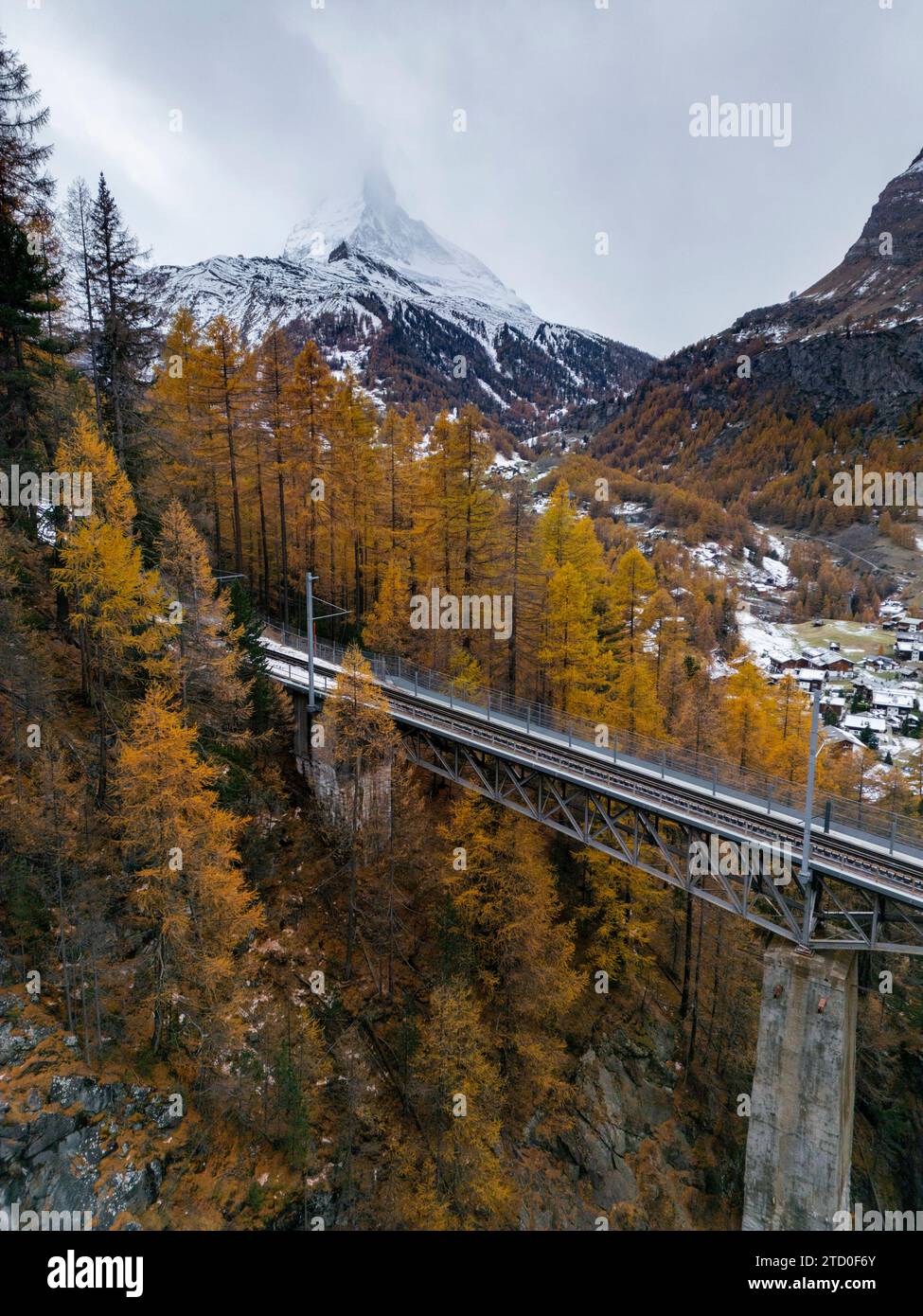 A breathtaking view of Switzerland's autumnal hues with a train bridge ...