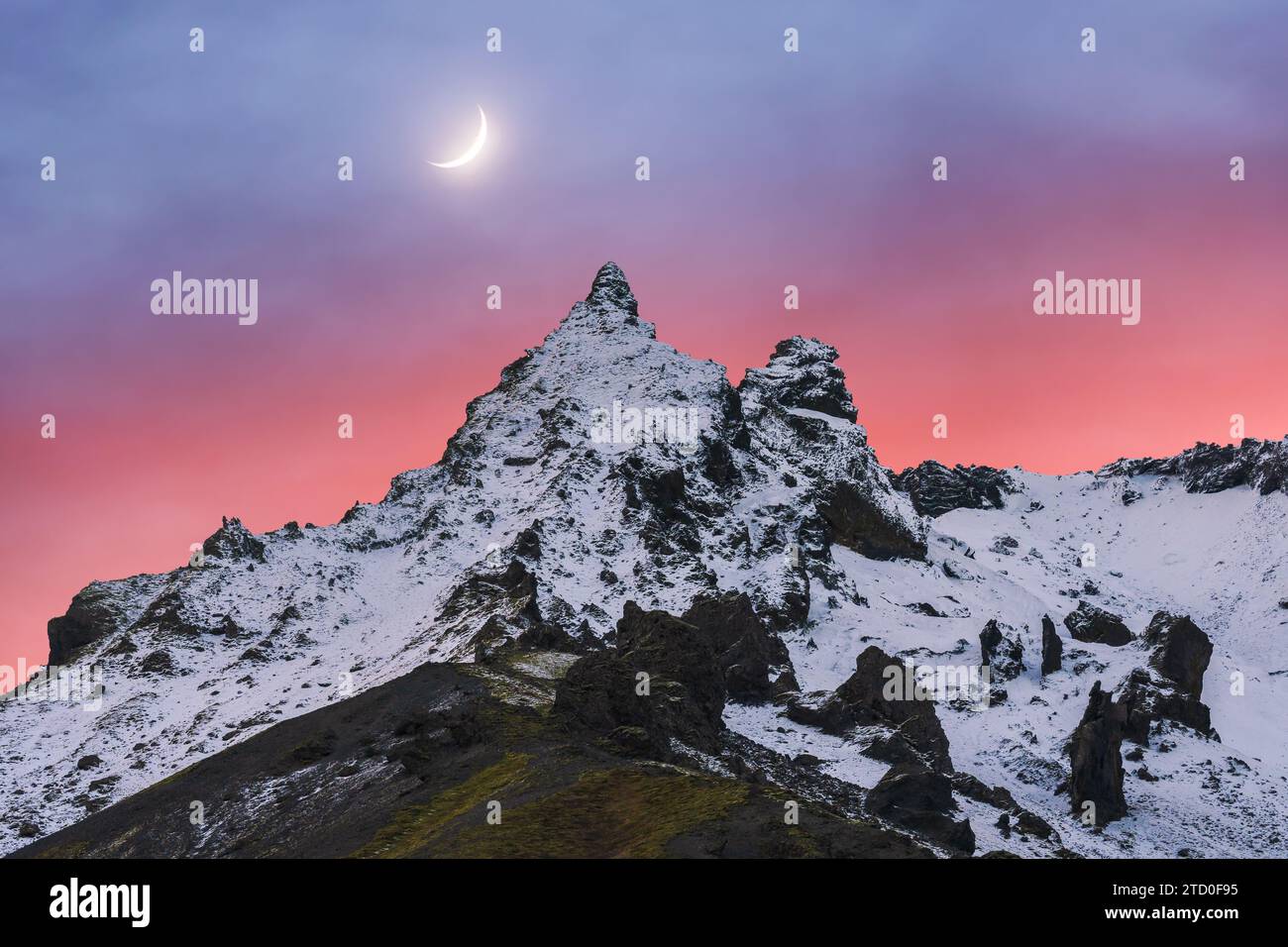 A majestic snow-capped mountain in Iceland stands under a glowing ...