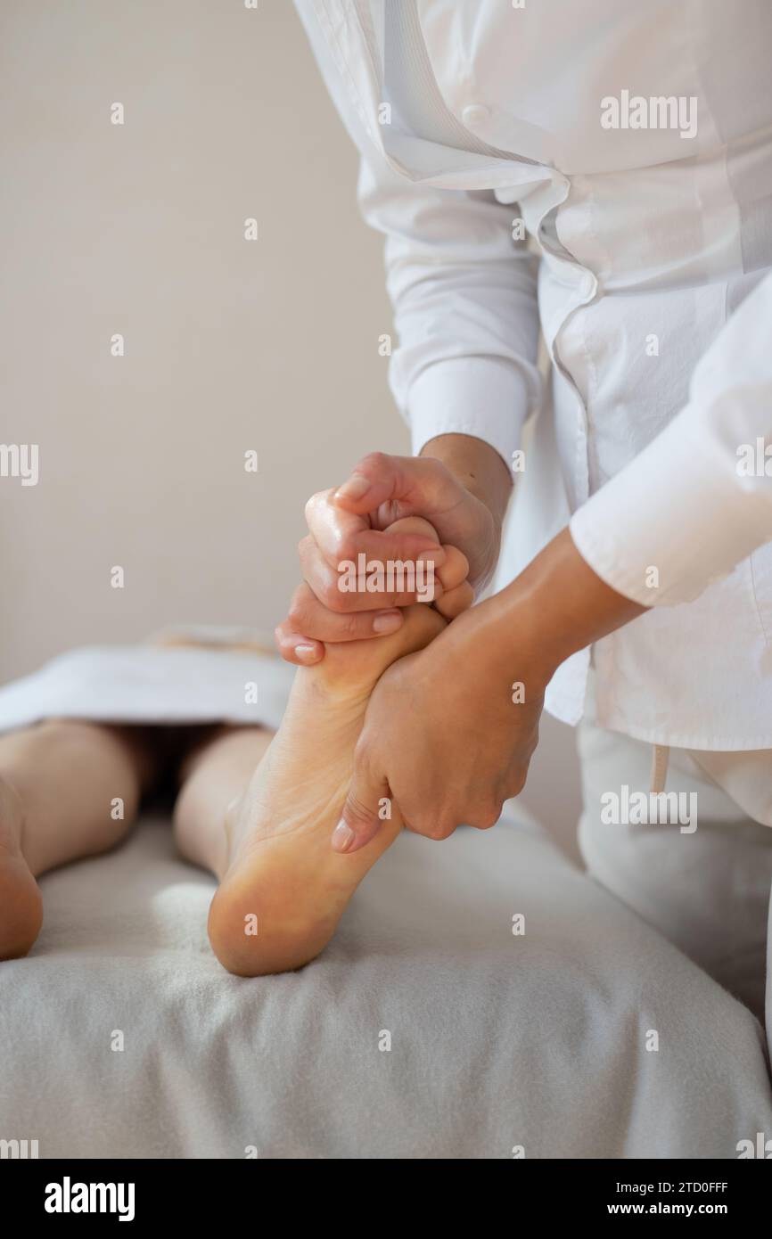 Crop Hands Of Anonymous Female Therapist Massaging Foot Of Customer
