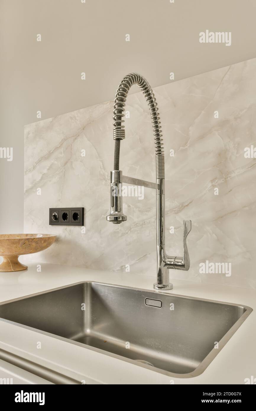 Stainless steel adjustable faucet over sink at kitchen counter in ...