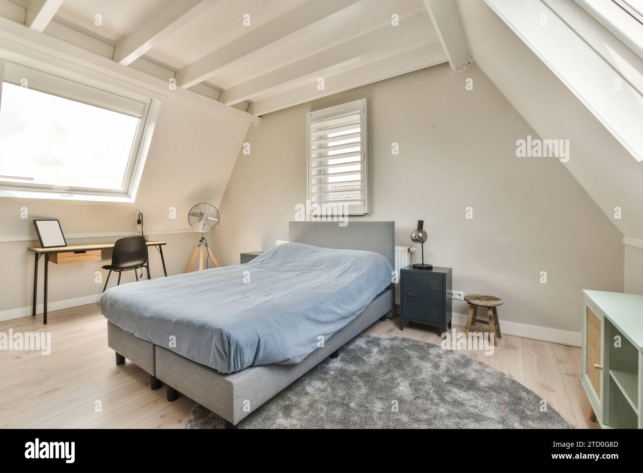 Cozy bed with desk and chair by window in loft spacious bedroom of ...