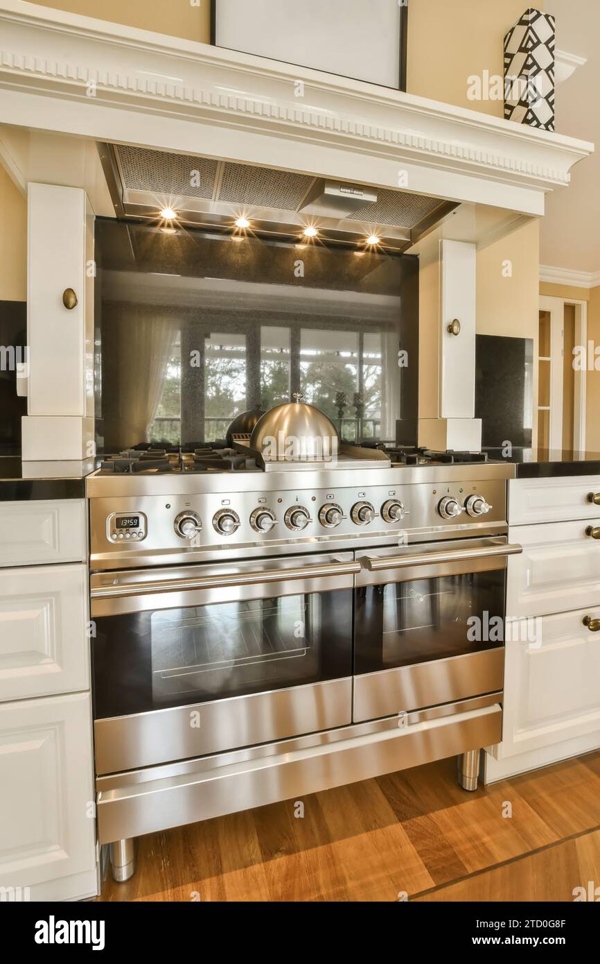 Modern built in stainless steel rangehood with illuminated lights over ...
