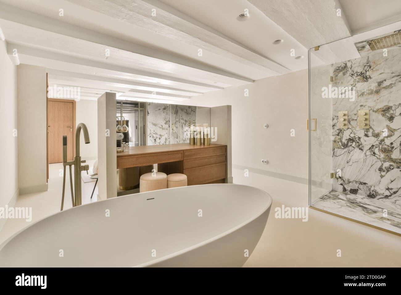 White bathtub and shower booth with dresser in spacious bathroom at ...