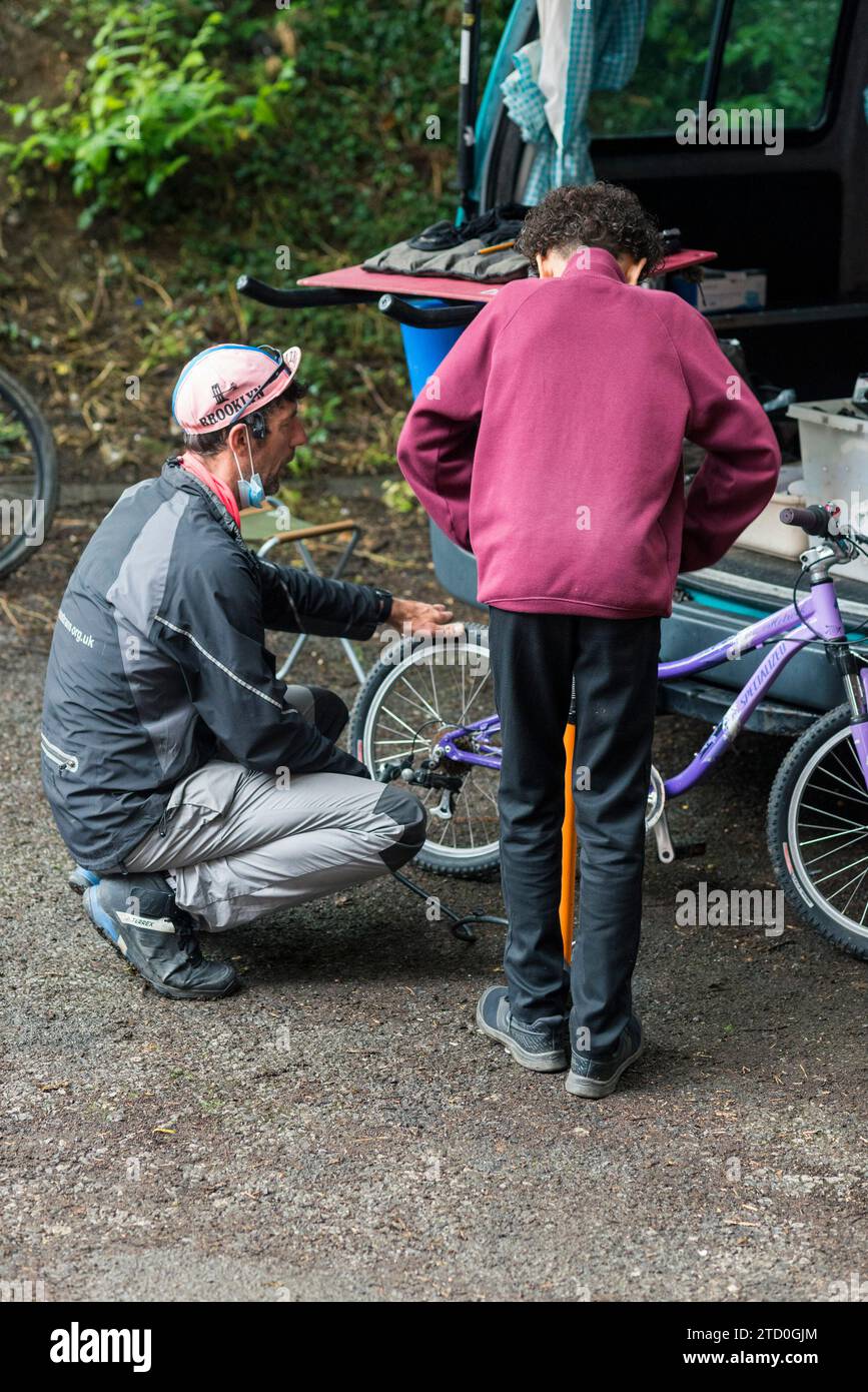 A man shows a student how to repair and maintain his bike so he can get ...