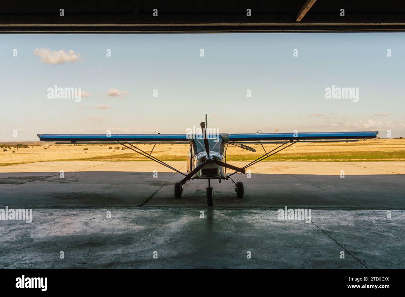 A single-engine aircraft is captured at rest in the hangar, with the ...