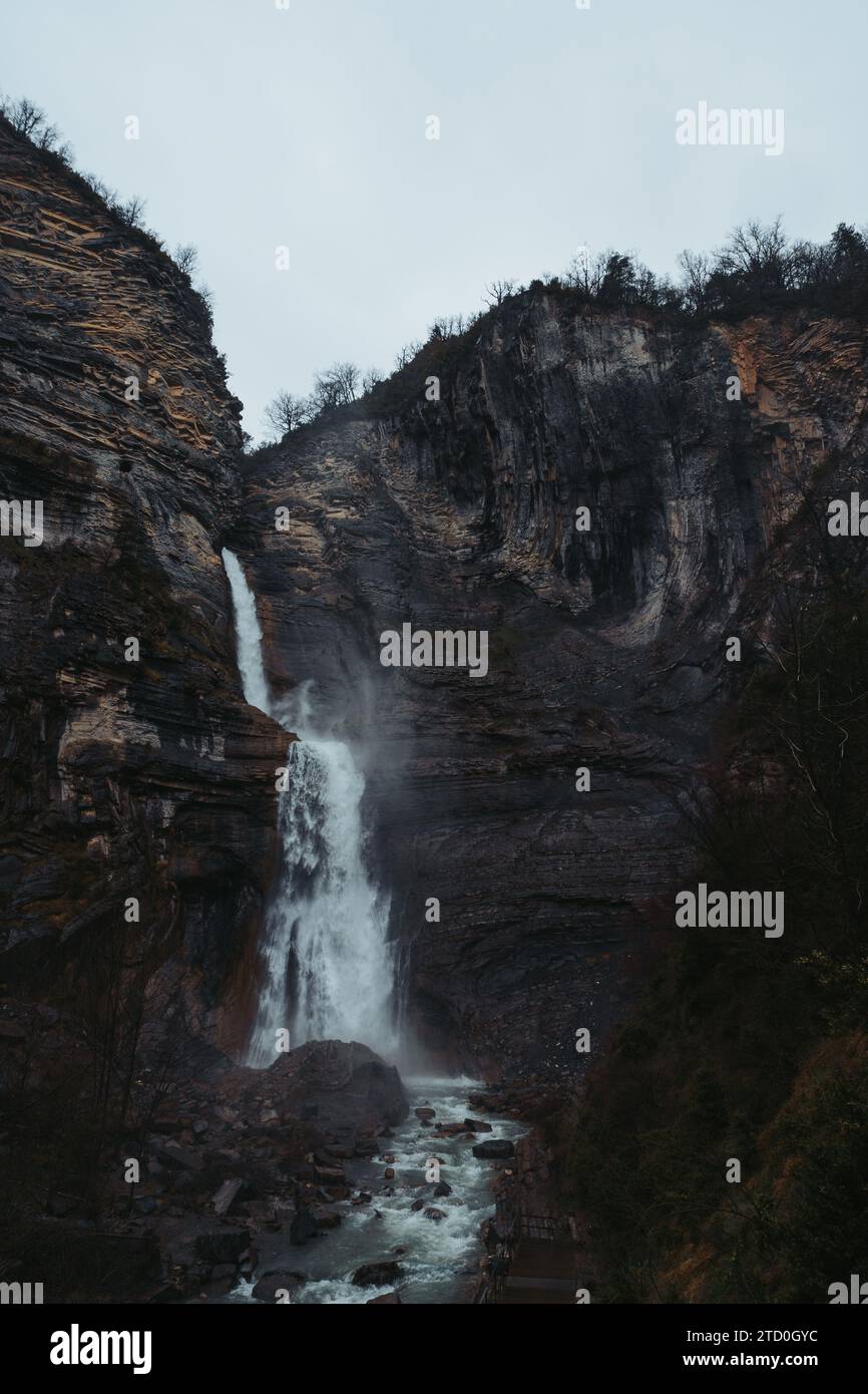 An awe-inspiring waterfall cascades down rugged cliffs into a rocky ...
