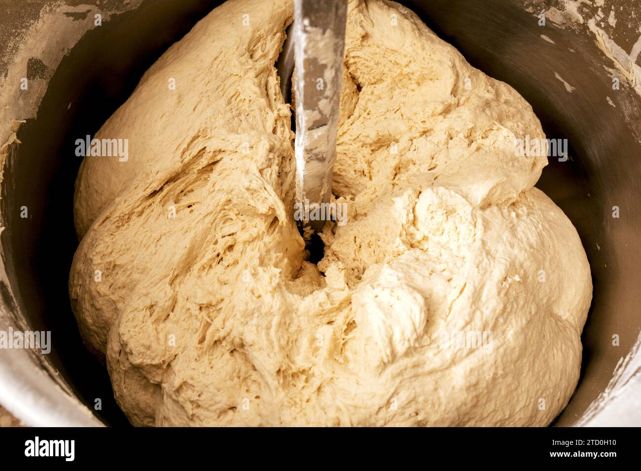 High angle view of fresh raw flour mixing in kneading machine for ...