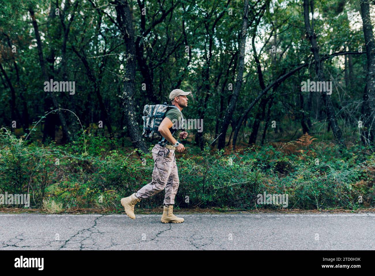 Full body side view of fit middle aged commando wearing uniform and ...