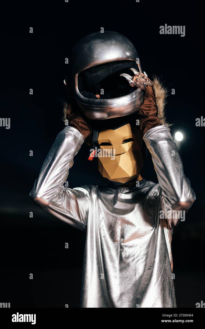 Anonymous person in silver costume wearing monkey mask with nails ...