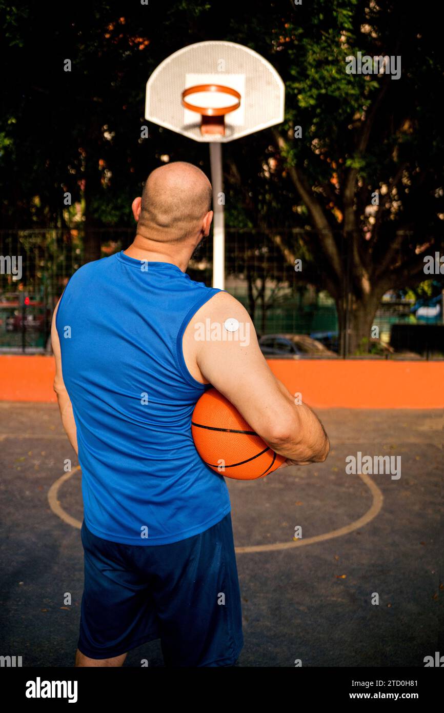 Back view of unrecognizable male in sportswear with sensor glucose ...