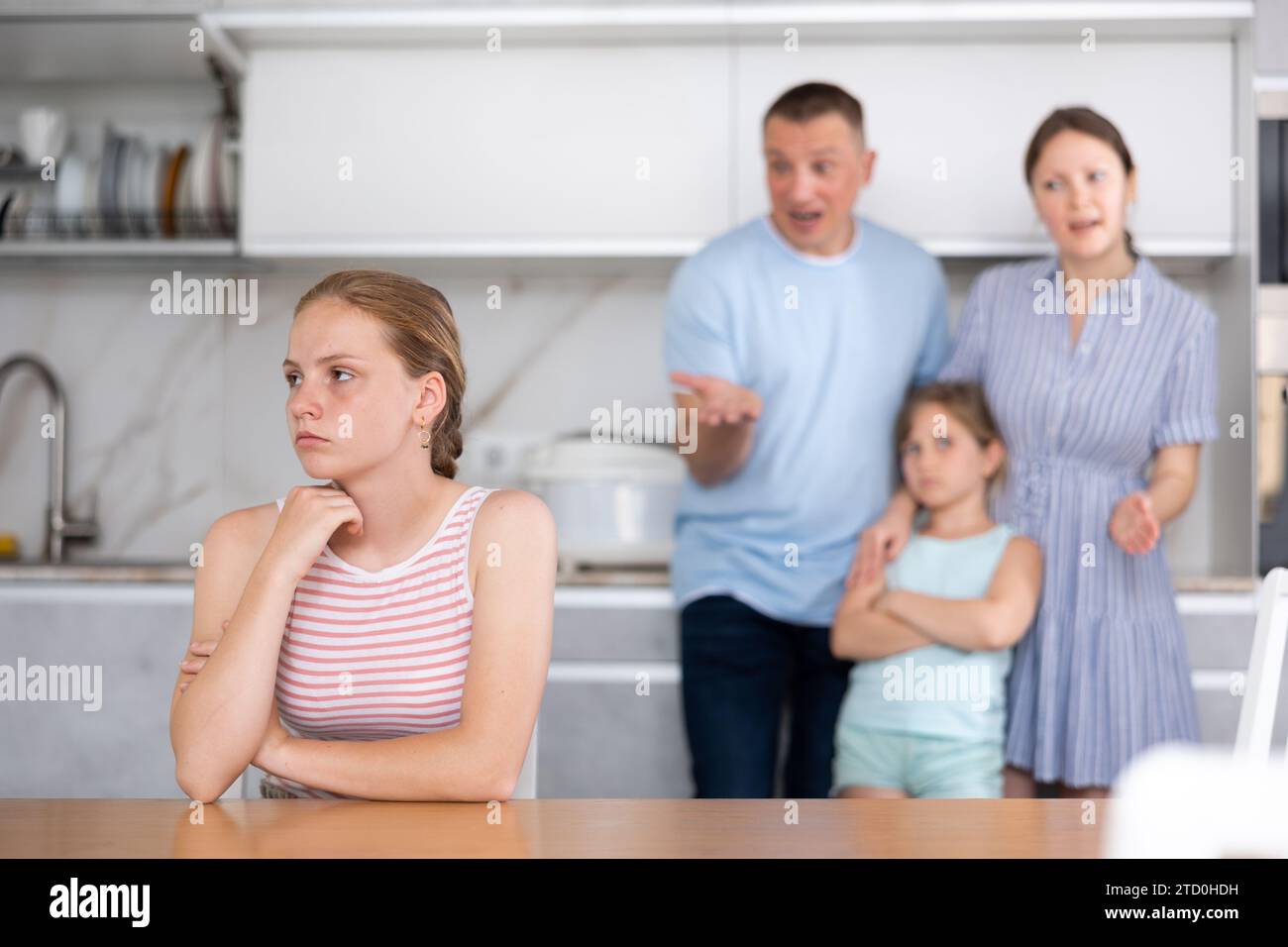 Upset teenage girl listening to disgruntled parents reprimanding her ...