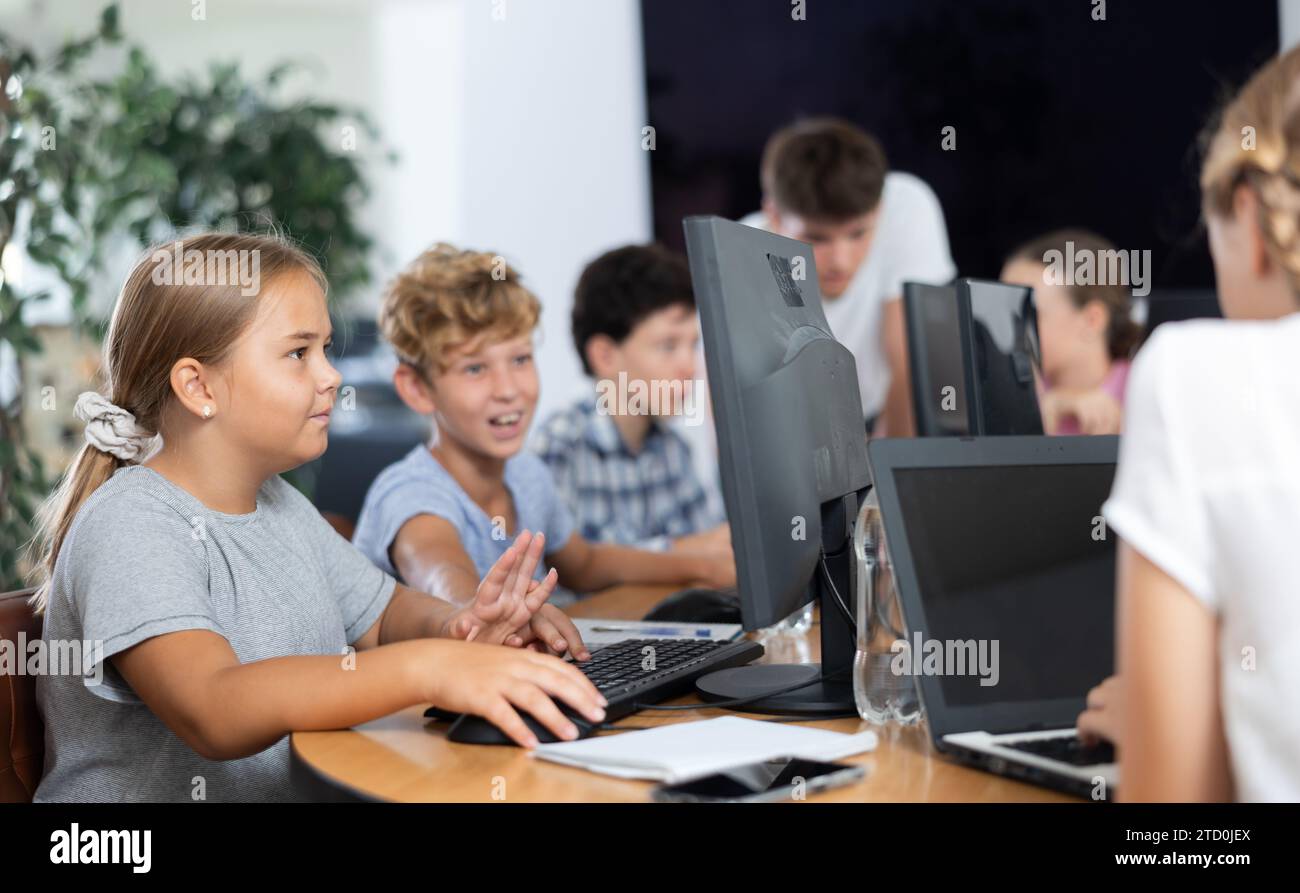 Computer science lesson in a school computer class - a girl and a boy ...