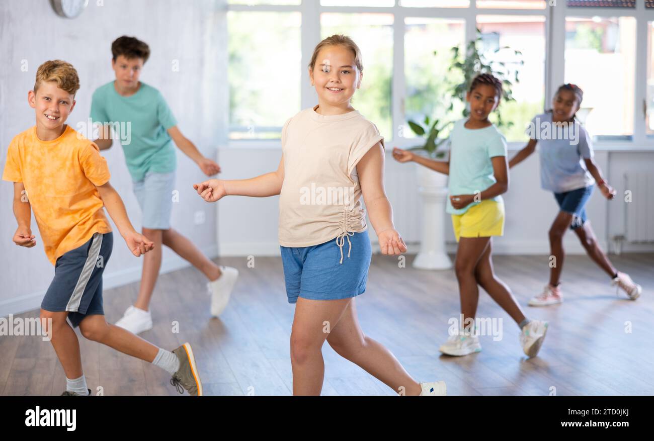 Smiling tween girl learning modern dynamic dances in choreography class ...