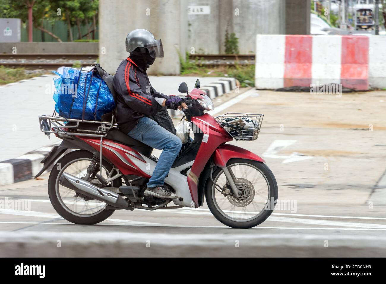 A man rides a motorcycle with a load down the street, Bangkok, Thailand ...