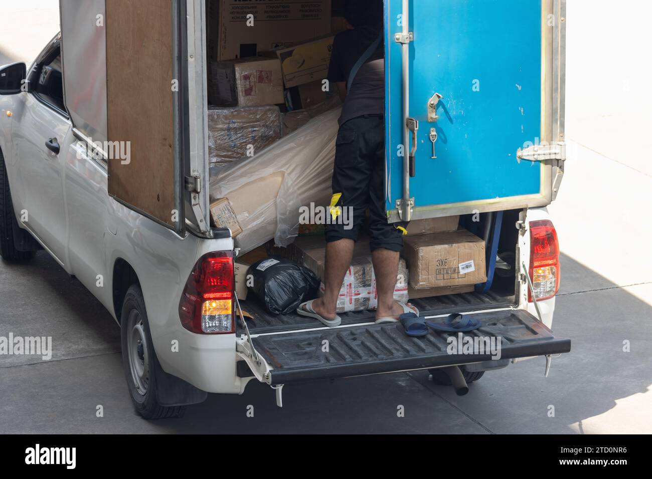 A delivery service courier is looking for parcels in a car Stock Photo ...
