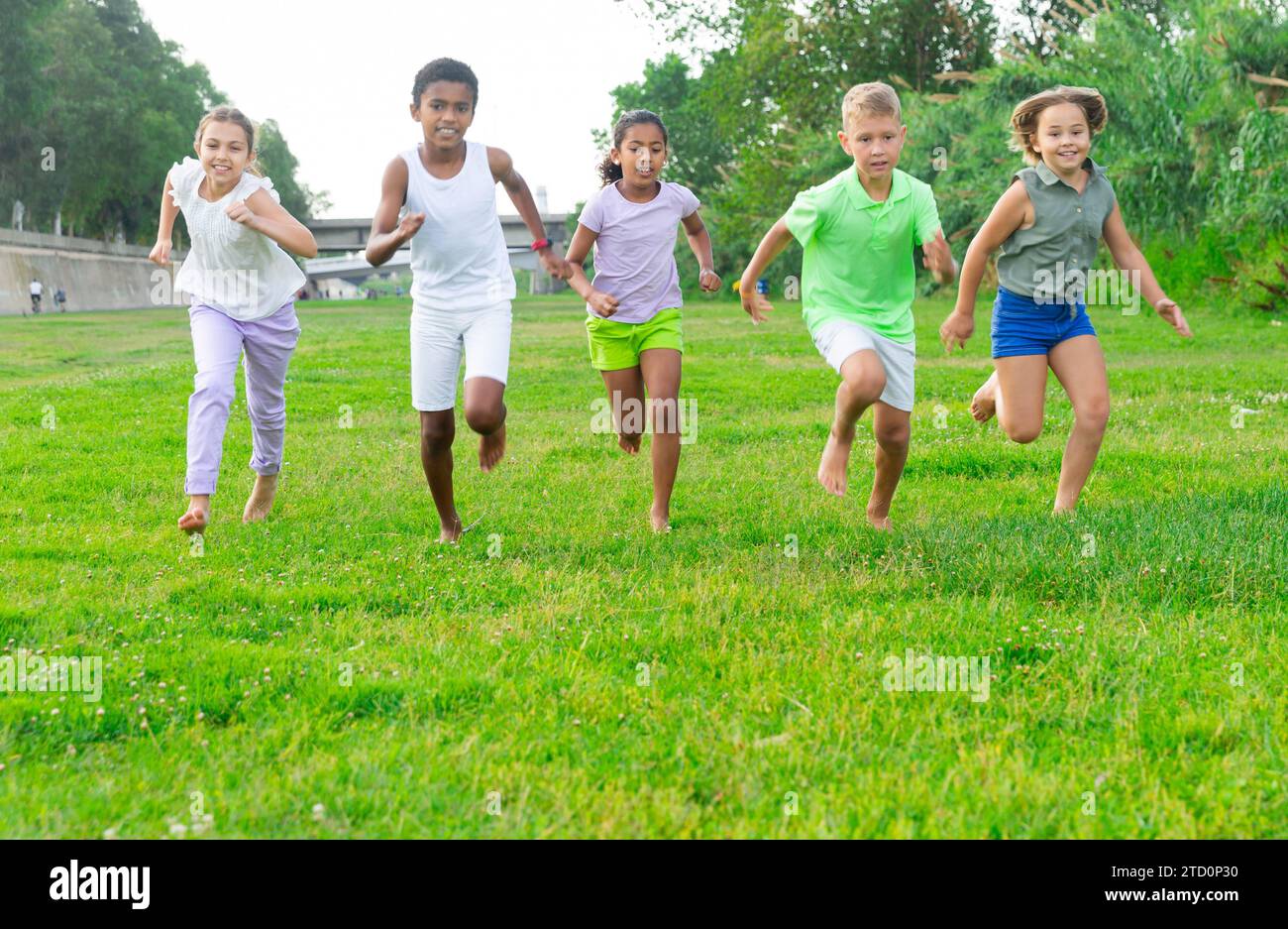 Barefoot kids running on green grass Stock Photo - Alamy