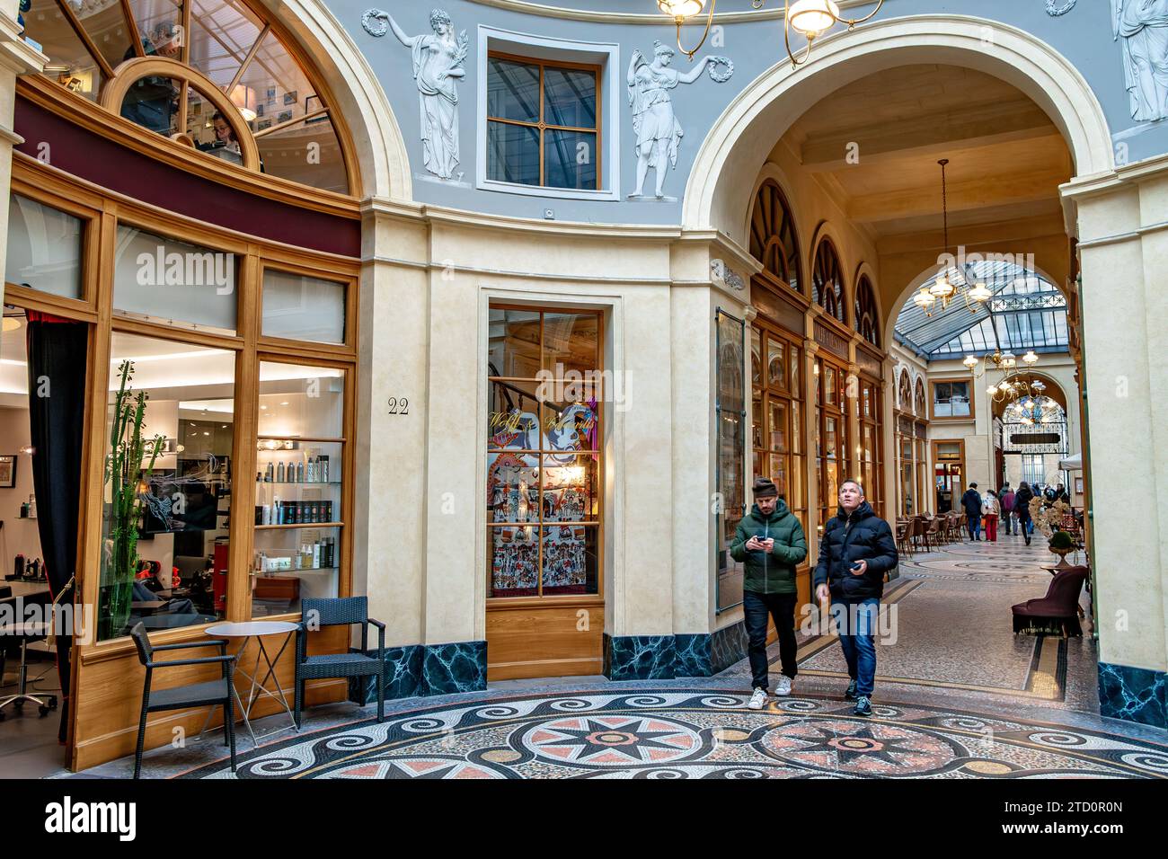 People walking through Galerie Vivienne, a beautiful covered shopping ...