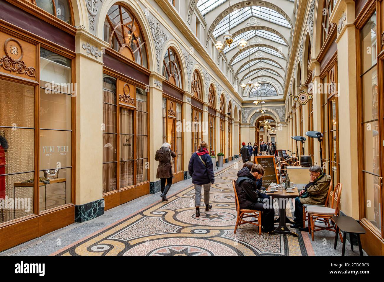 People walking through Galerie Vivienne, a beautiful covered shopping ...