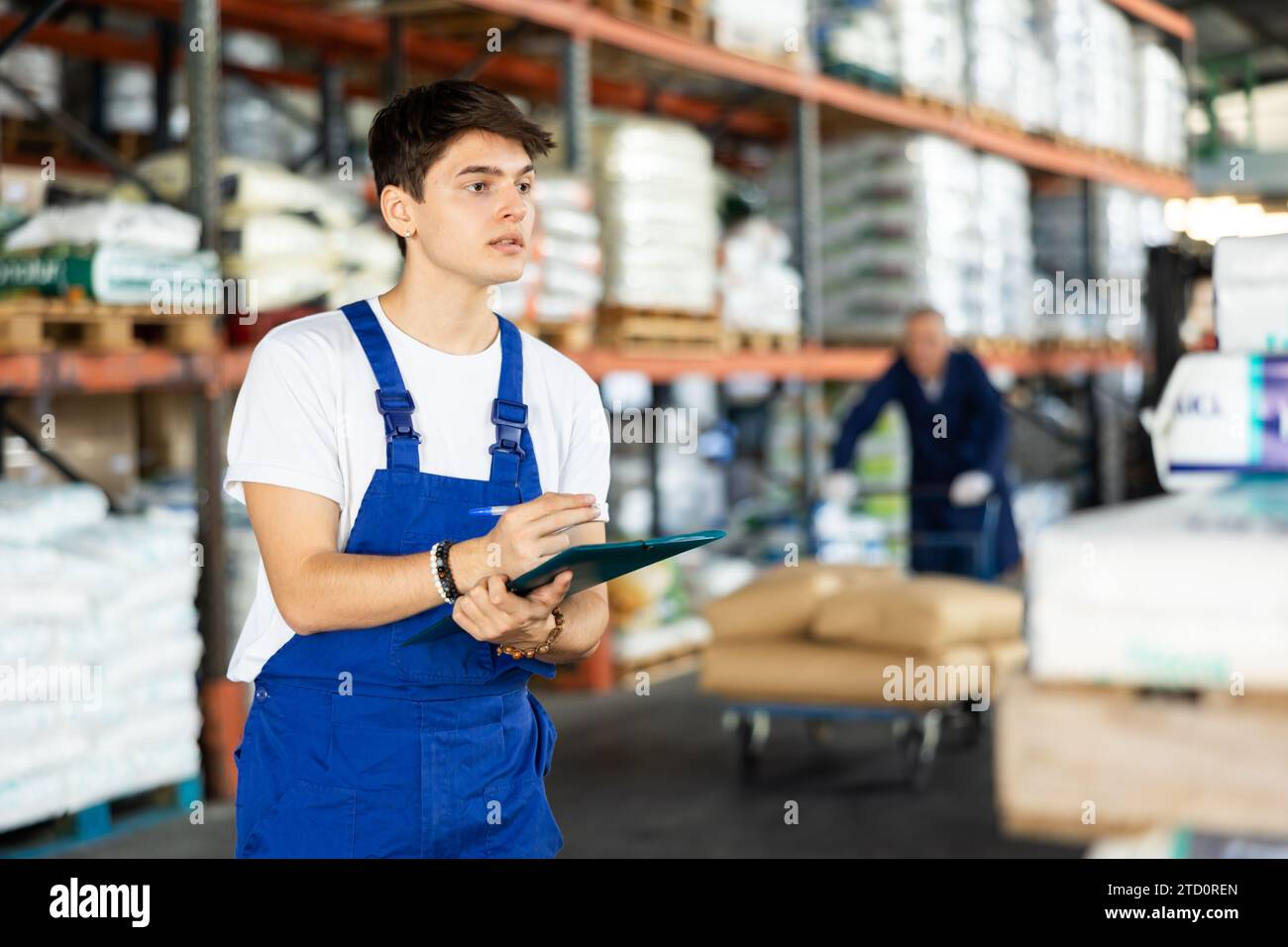 Young guy warehouse worker checking documents Stock Photo - Alamy