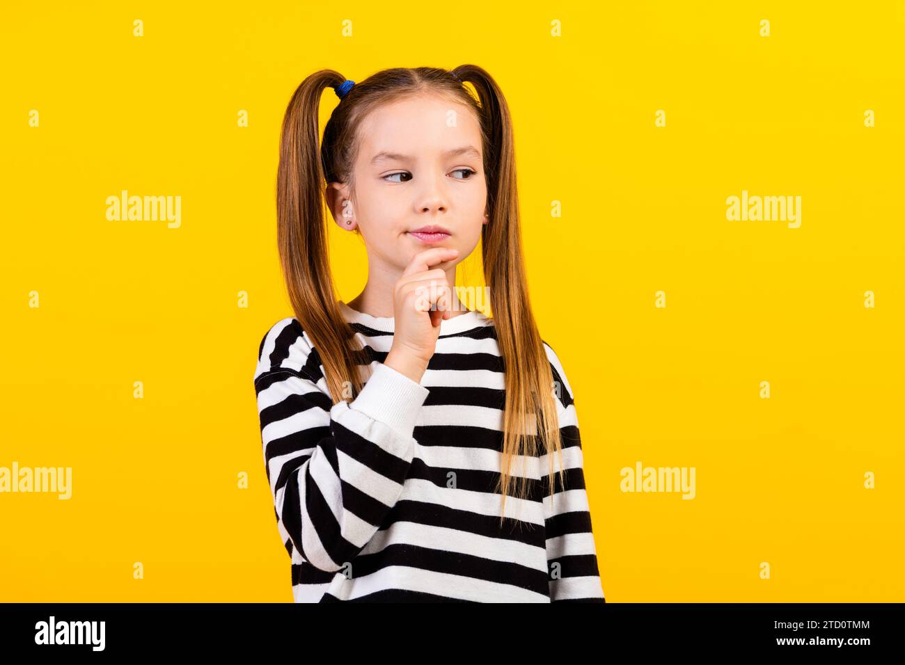 Photo of doubtful unsure little child dressed striped pullover arm chin looking empty space ...
