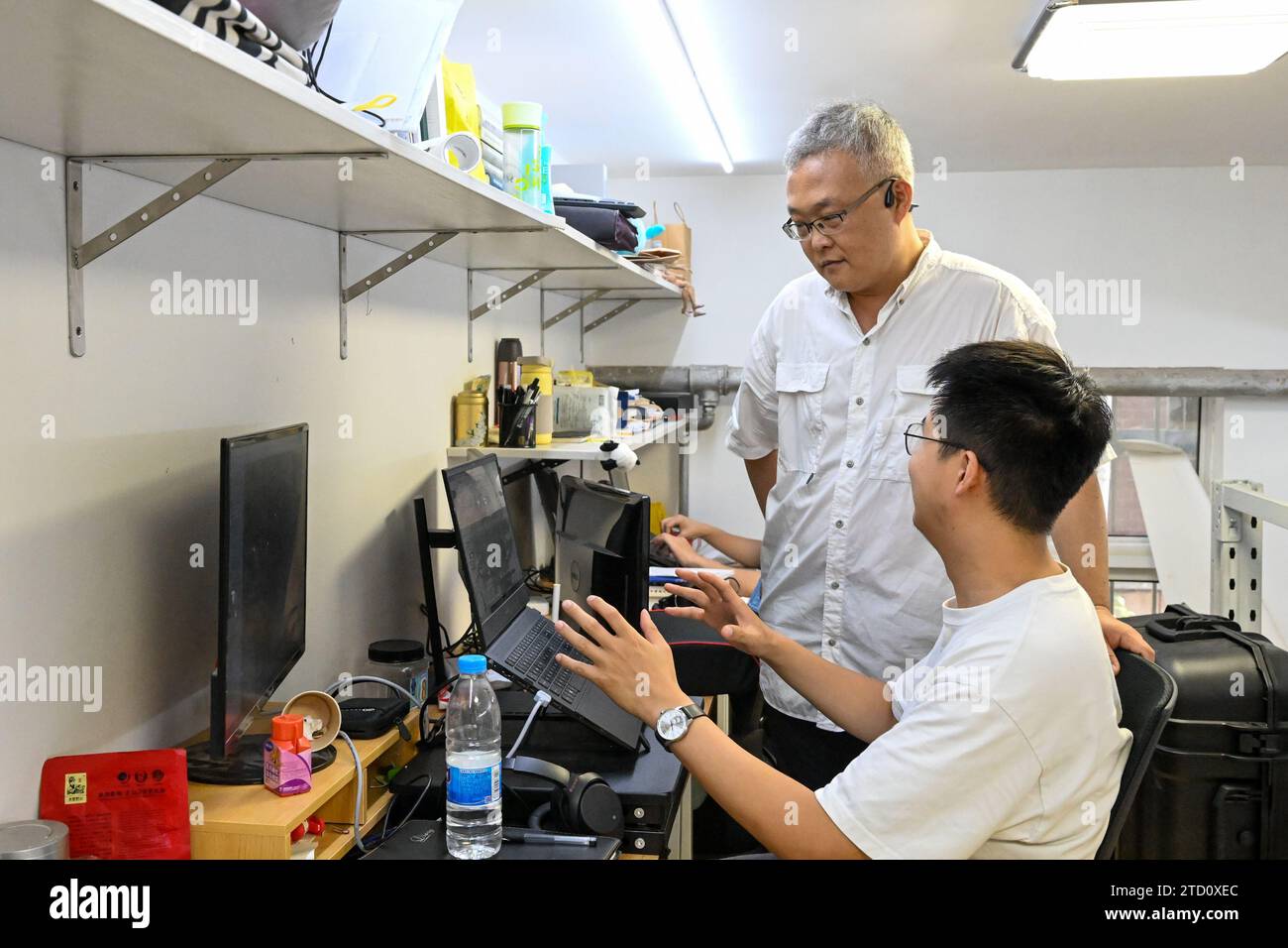 (231215) -- TIANJIN, Dec. 15, 2023 (Xinhua) -- Li Zhe (back) talks with ...