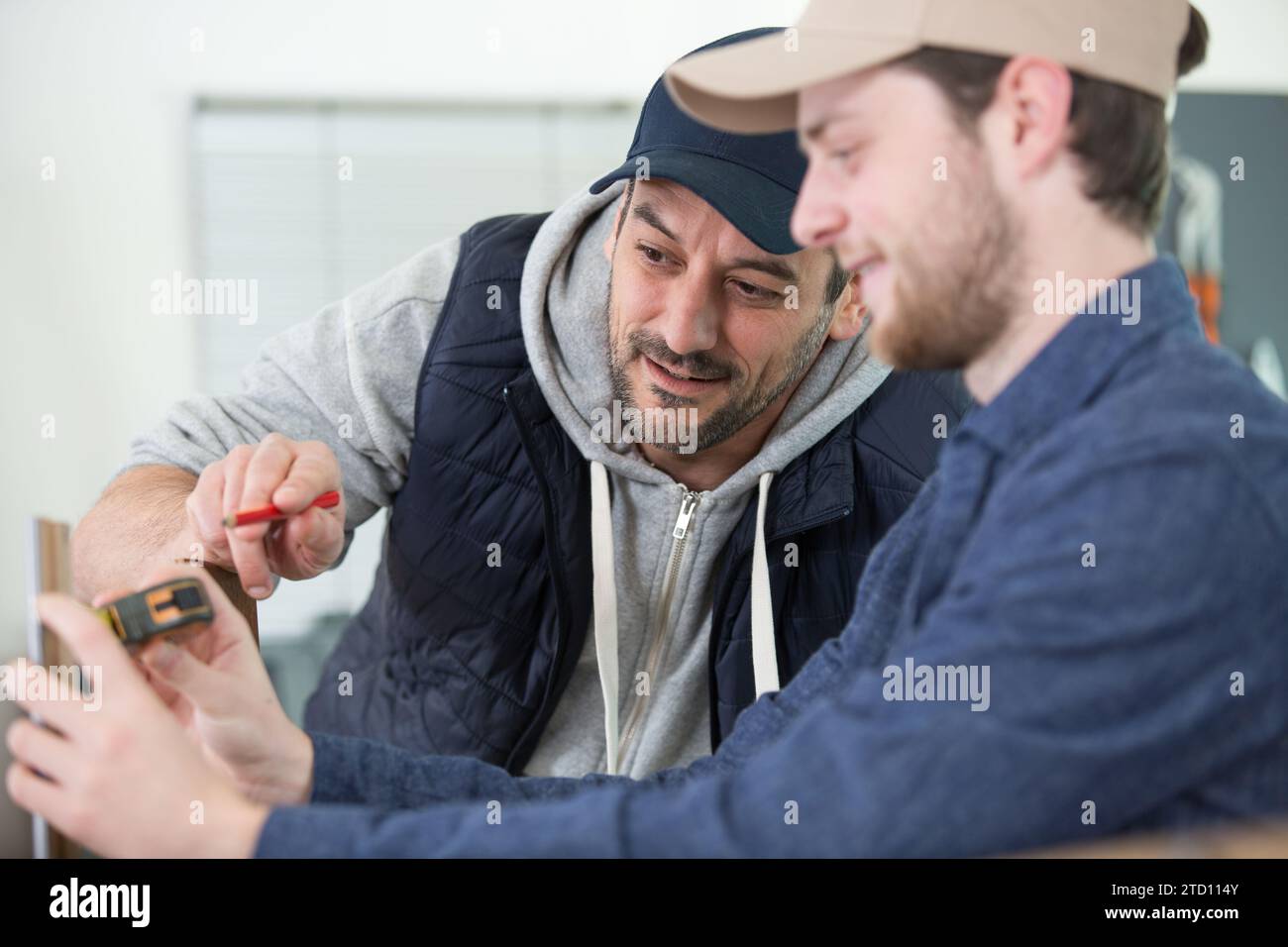 carpenter teaching apprentice how to measure wood Stock Photo - Alamy