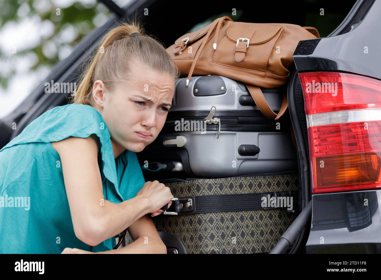 woman struggling to put her suitcase in taxi trunk Stock Photo - Alamy