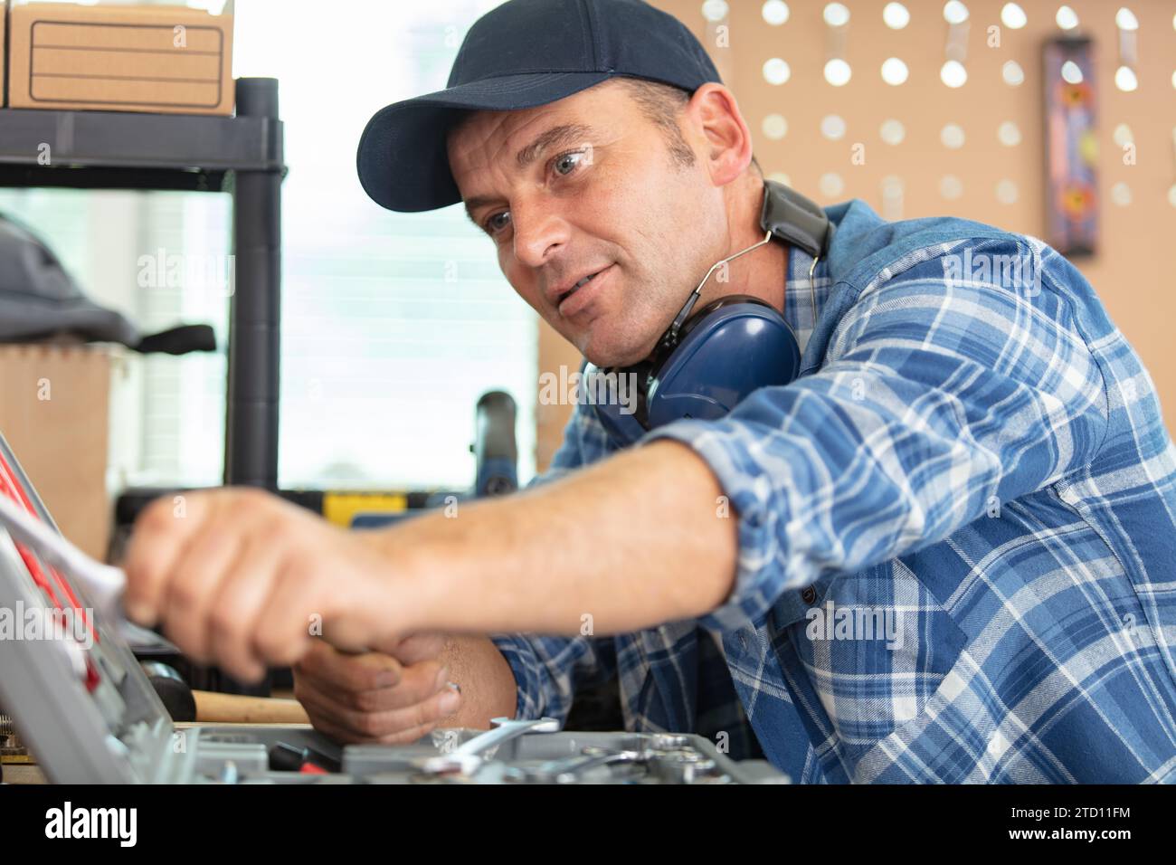 man in workshop reaches for a tool Stock Photo - Alamy