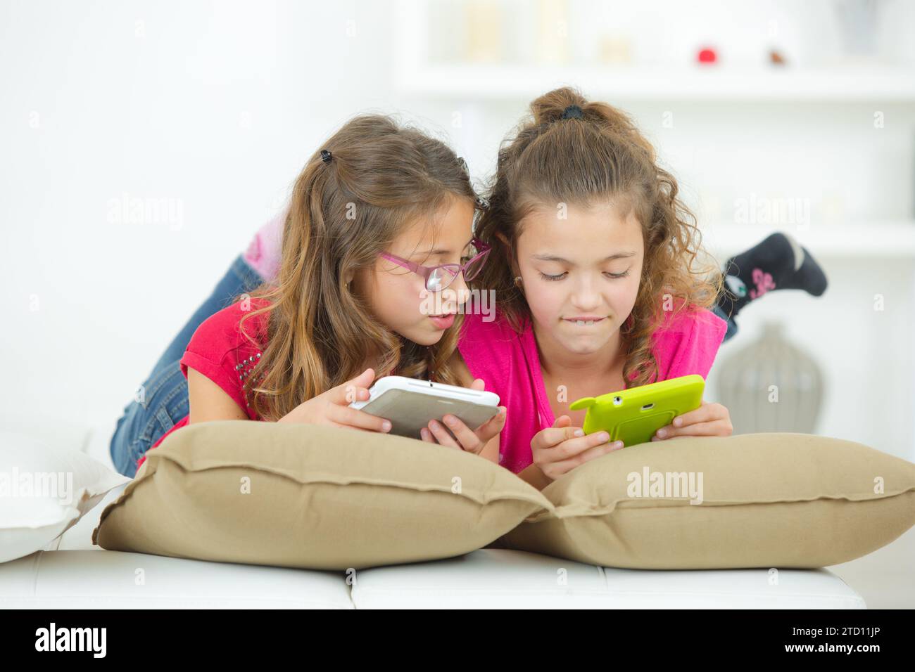 two girls playing on tablets Stock Photo - Alamy