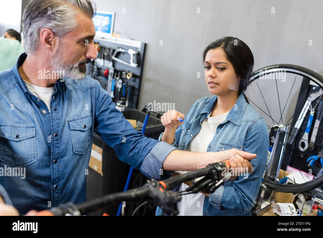 female bicycle mechanic with teacher Stock Photo - Alamy