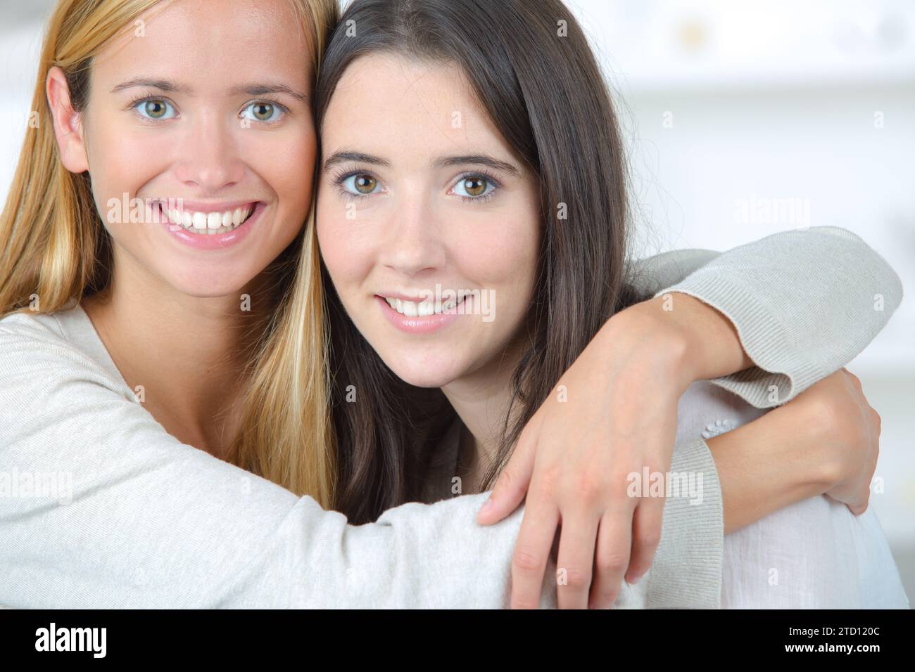 childhood friends are hugging in front of the camera Stock Photo - Alamy