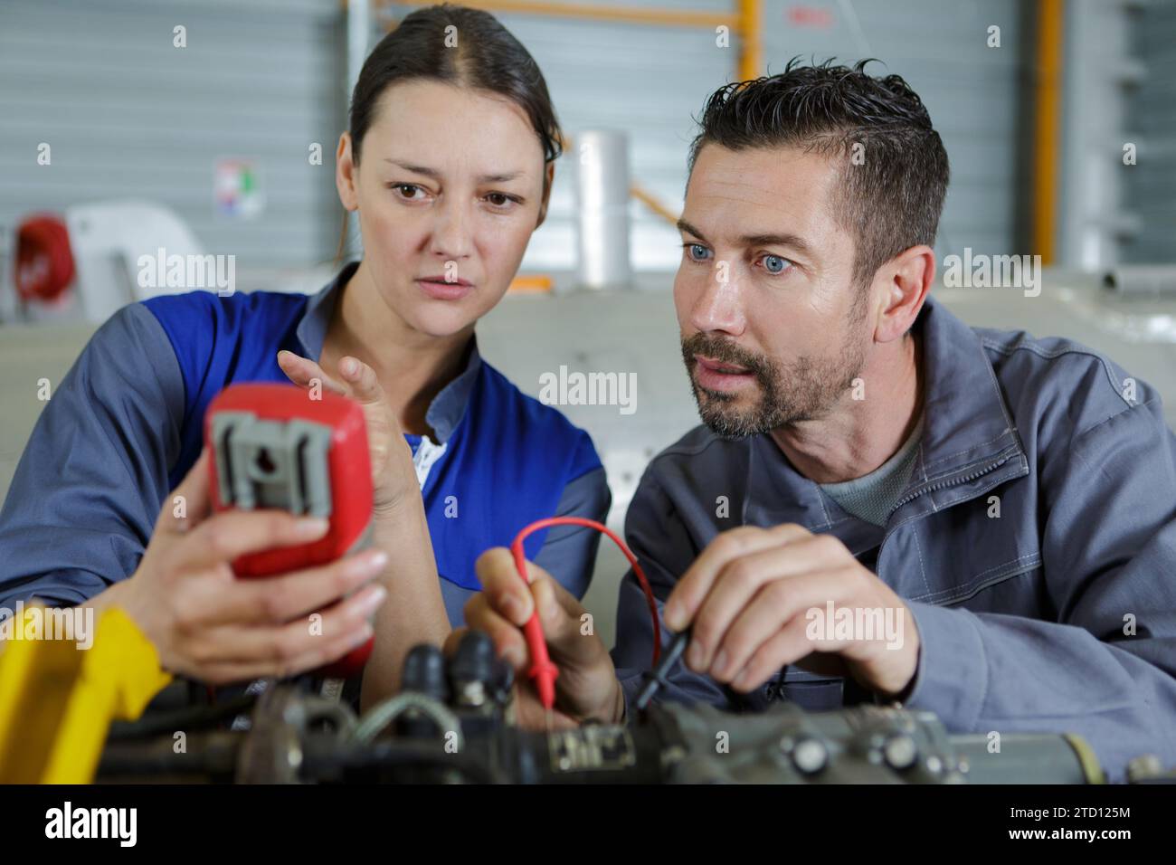 couple of mechanics repairing an engine of a race car Stock Photo - Alamy