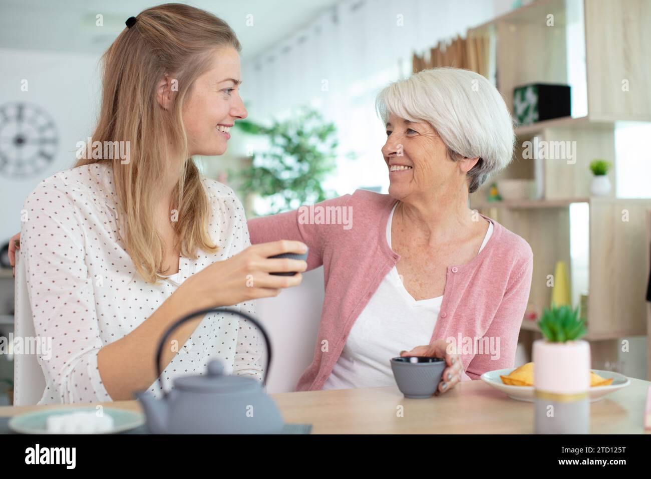 young woman giving tea at her mum Stock Photo - Alamy