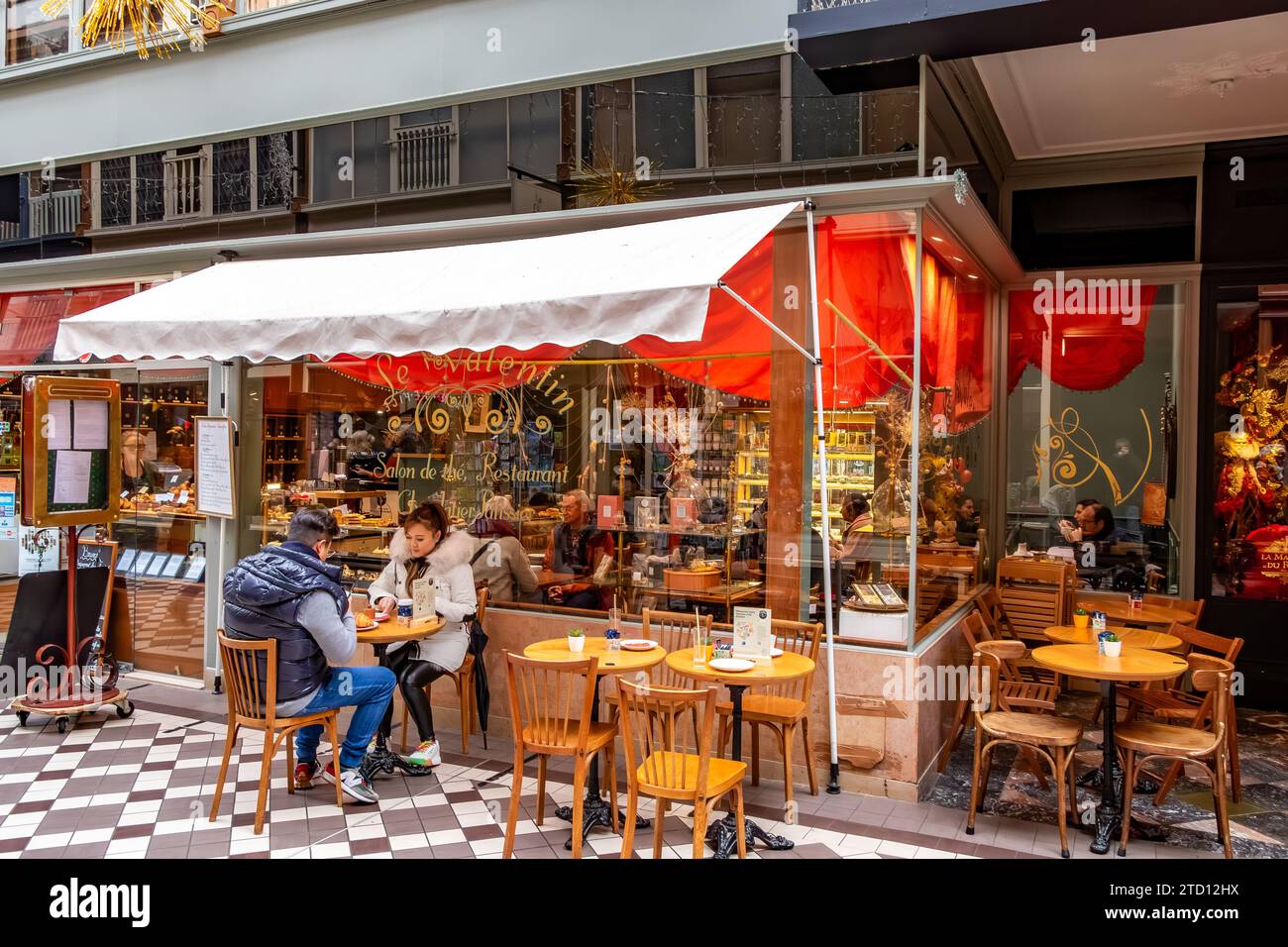 A couple sitting outside Le Valentin Jouffroy ,a beautiful cafe inside ...