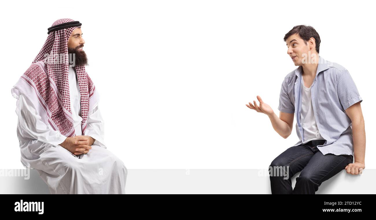 Young man and an arab sitting on a wall and talking isolated on white ...