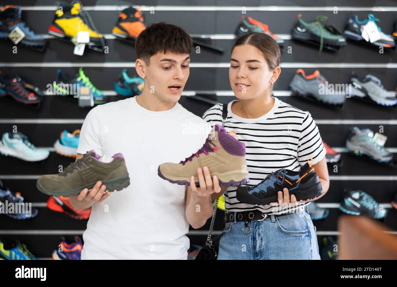 Guy and girl choose climbing shoes together in sports store Stock Photo ...