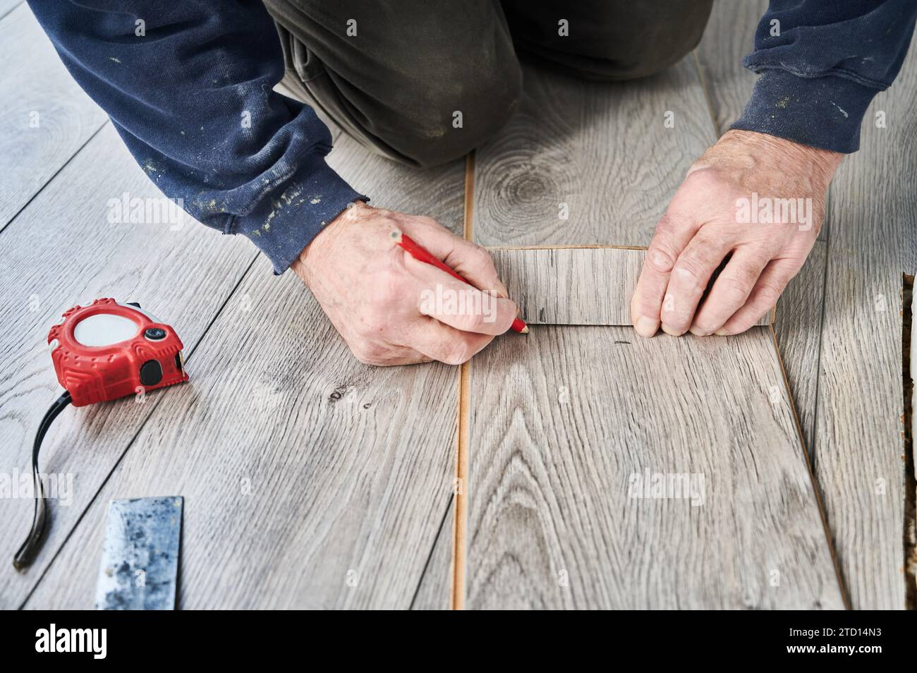 Close up of man construction worker with pencil in hand drawing line on ...