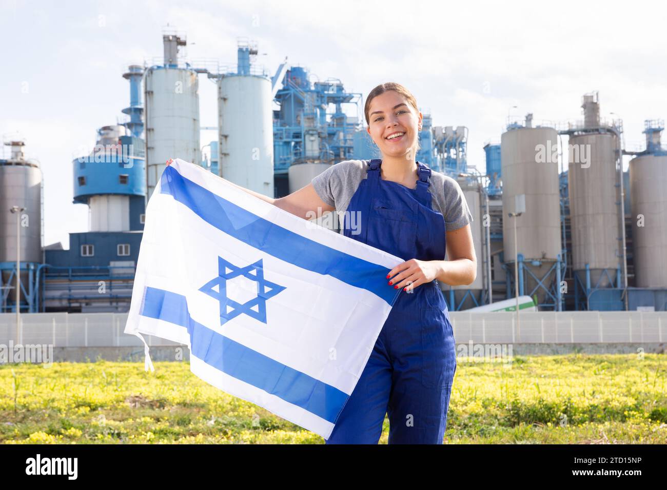 Smiling young woman near factory with Israel flag Stock Photo - Alamy