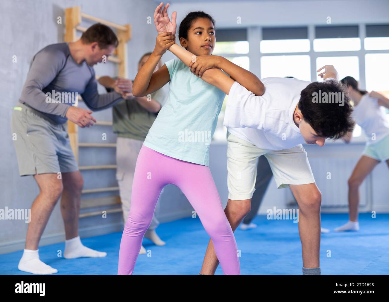 Preteen children pairs learning strength self-defense in gym Stock ...