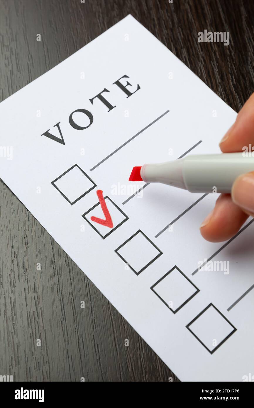Hand puts a vote mark. Election concept Stock Photo - Alamy