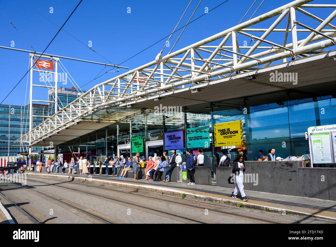 People waiting for a tram at a stop outside East Croydon railway station, Croydon, England Stock ...