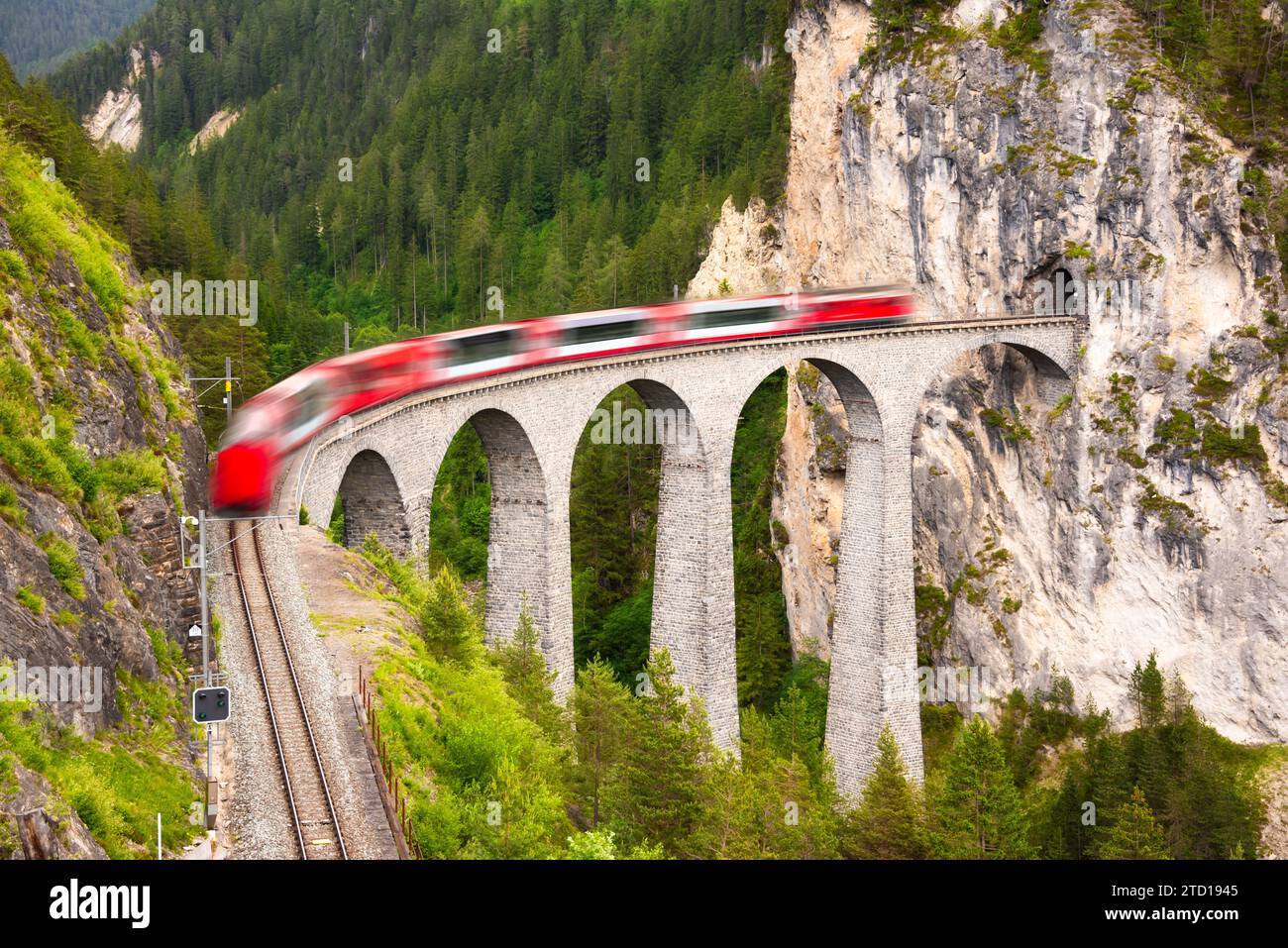 Swiss red train on viaduct in mountain for scenic ride Stock Photo - Alamy