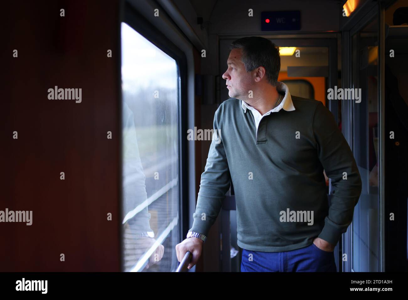 man stay into the train and look out from window Stock Photo - Alamy