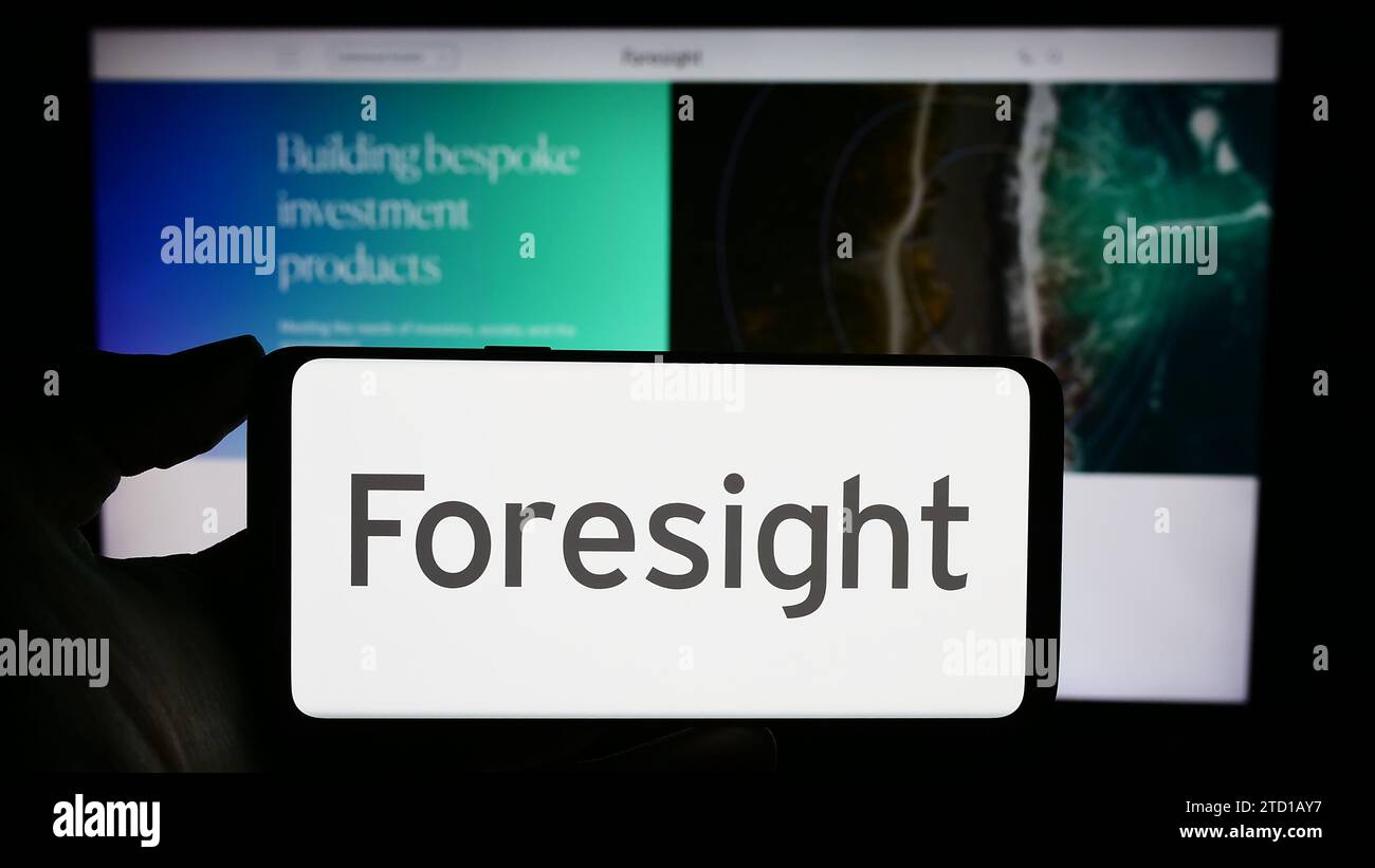 Person holding cellphone with logo of British investment company Foresight Group Holdings plc in ...